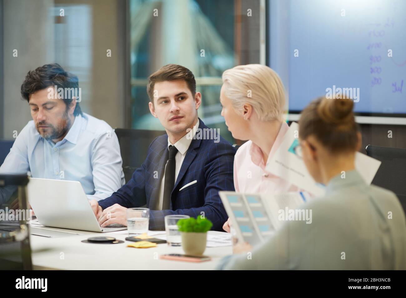Business people cooperating with each other while sitting at the table ...