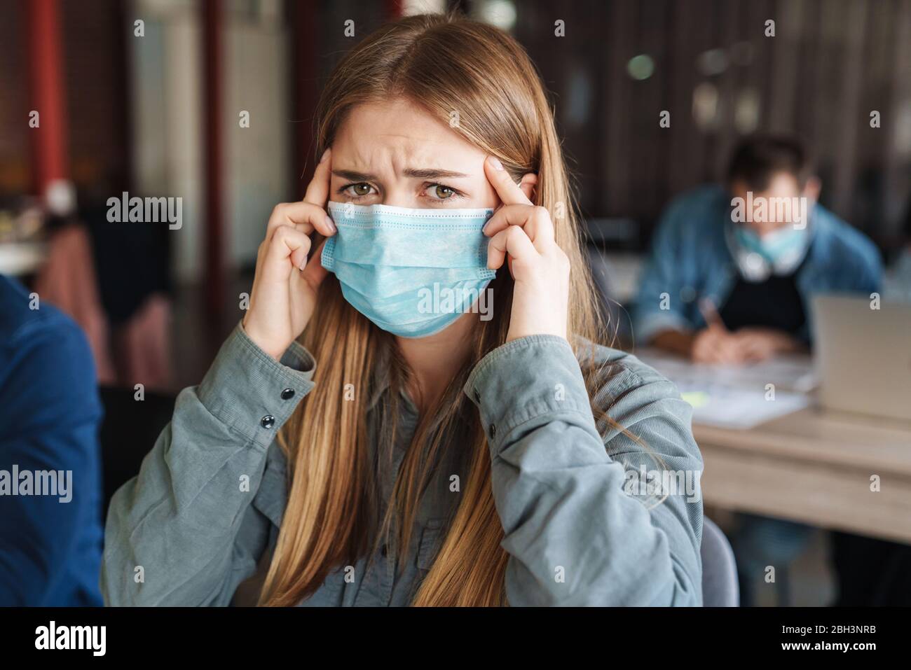 Photo of caucasian young student with headache in medical masks ...