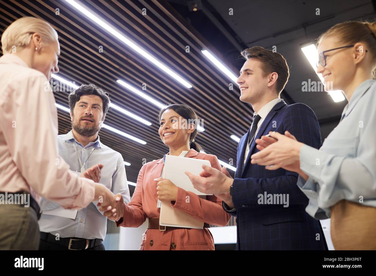 Two businesswomen shaking hands to each other they concluding a deal ...