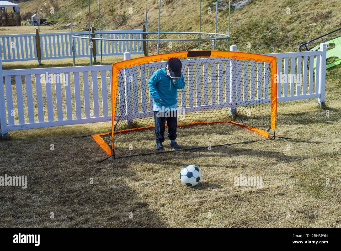 Stay at home. COVID 19. Close up view of boy playing football on ...