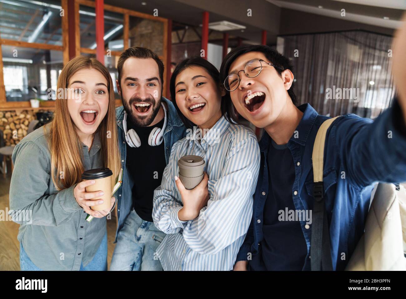 Photo of multinational cheerful students laughing while taking selfie ...