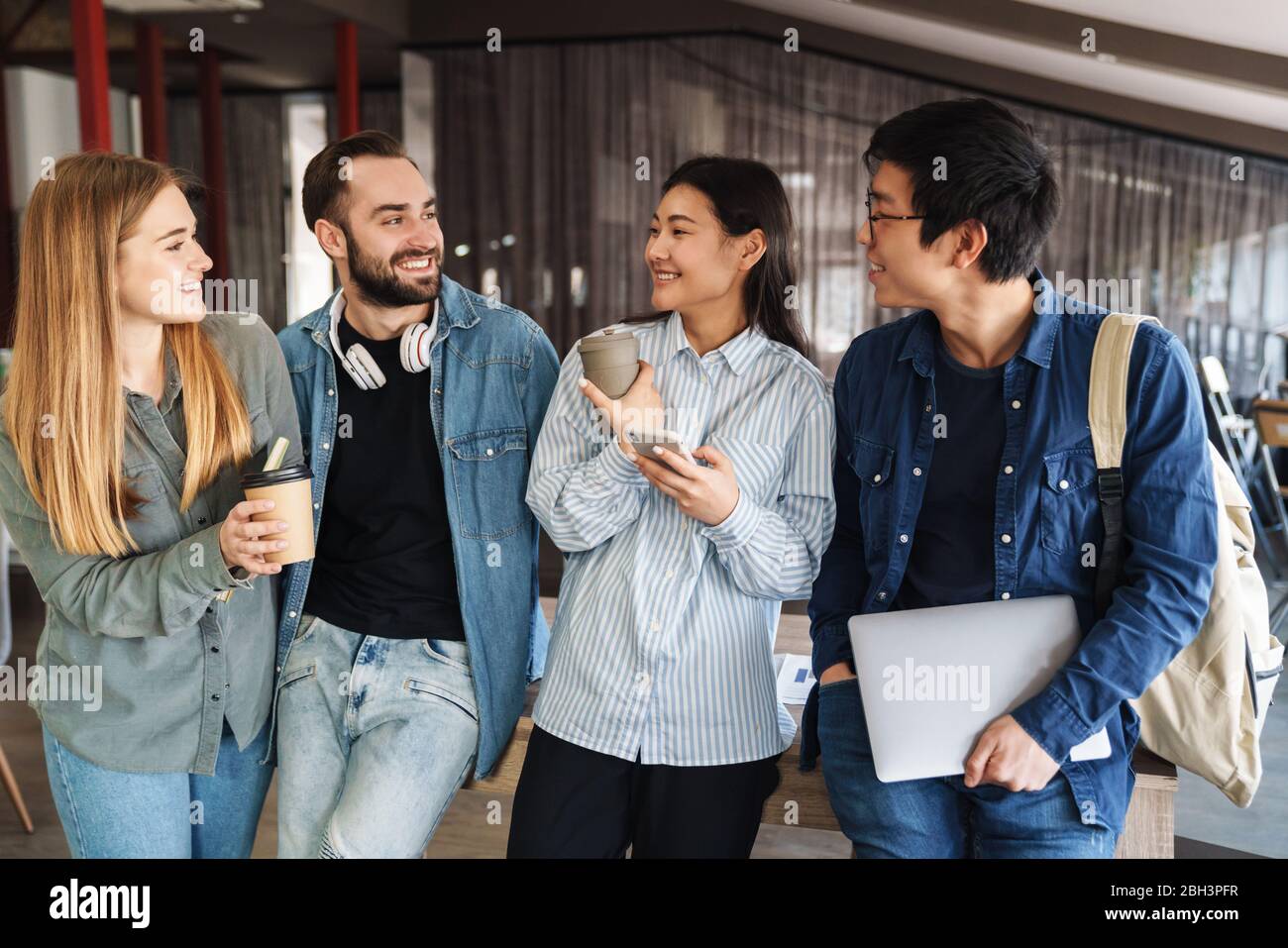 Photo of multinational cheerful students laughing and talking while ...
