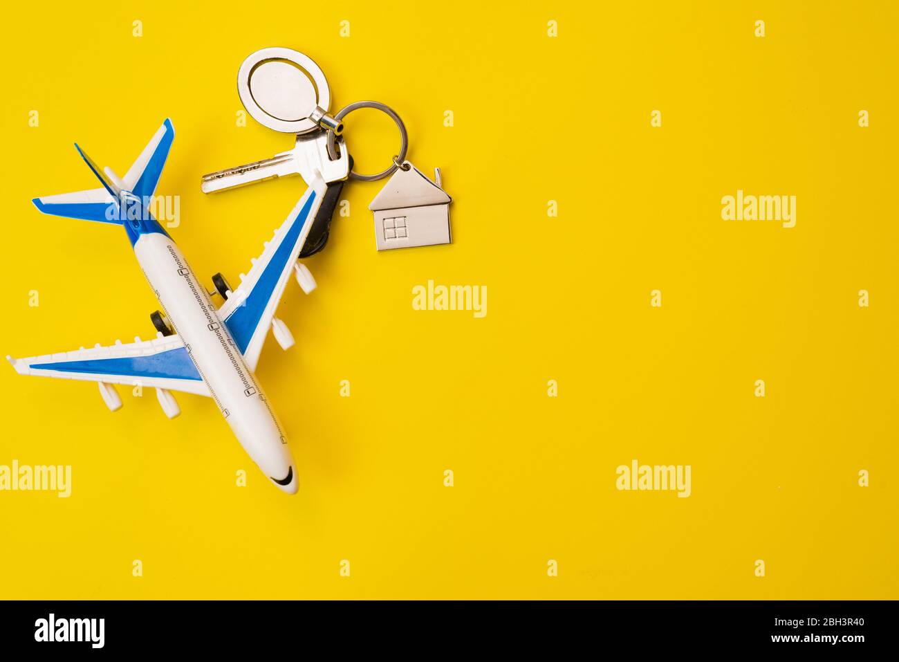 The concept of flying home, return. Airplane model and apartment keys ...