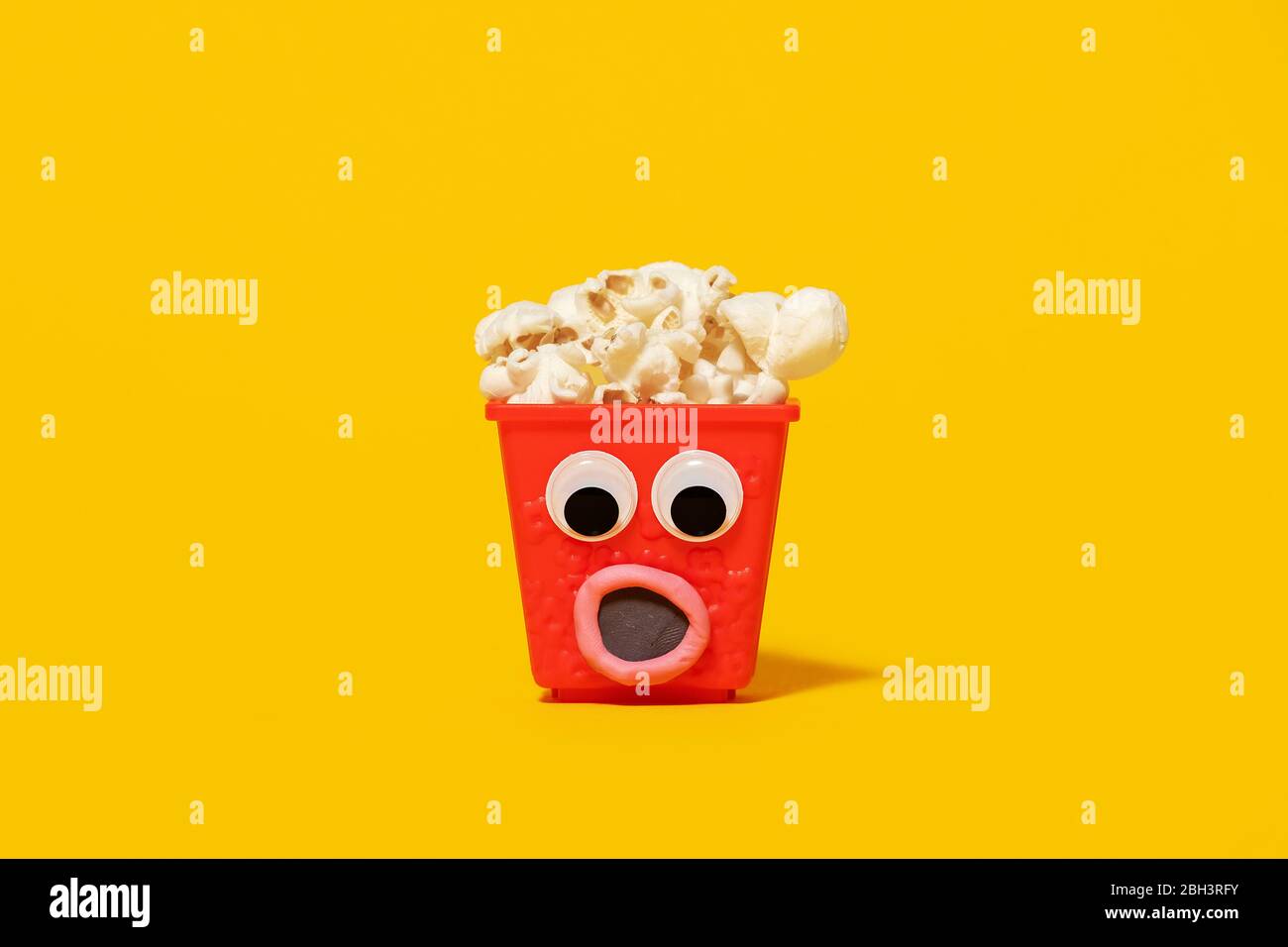 Red popcorn box carton with googly eyes and surprised face with popped ...