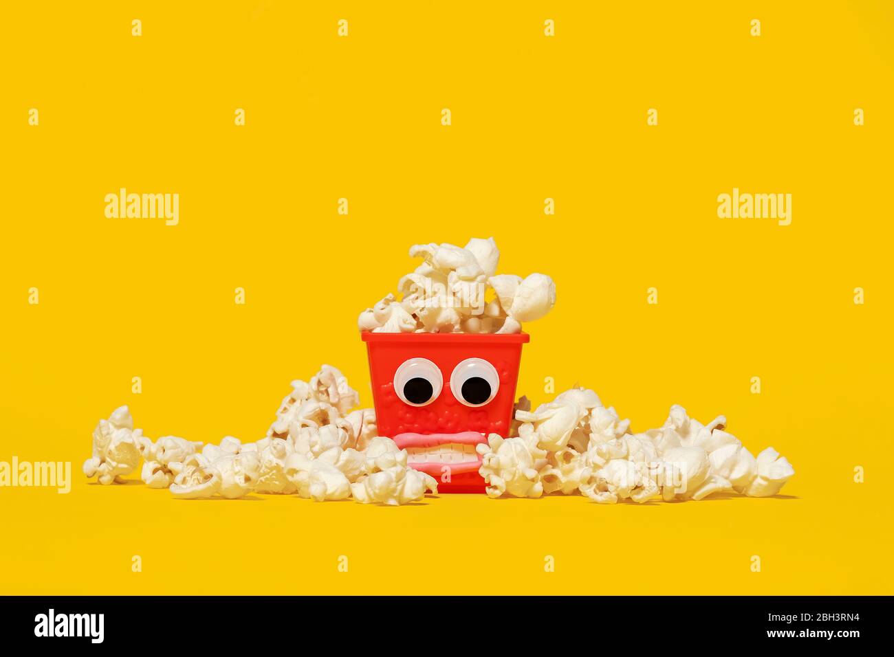 Red popcorn box carton with googly eyes and angry face with popped ...