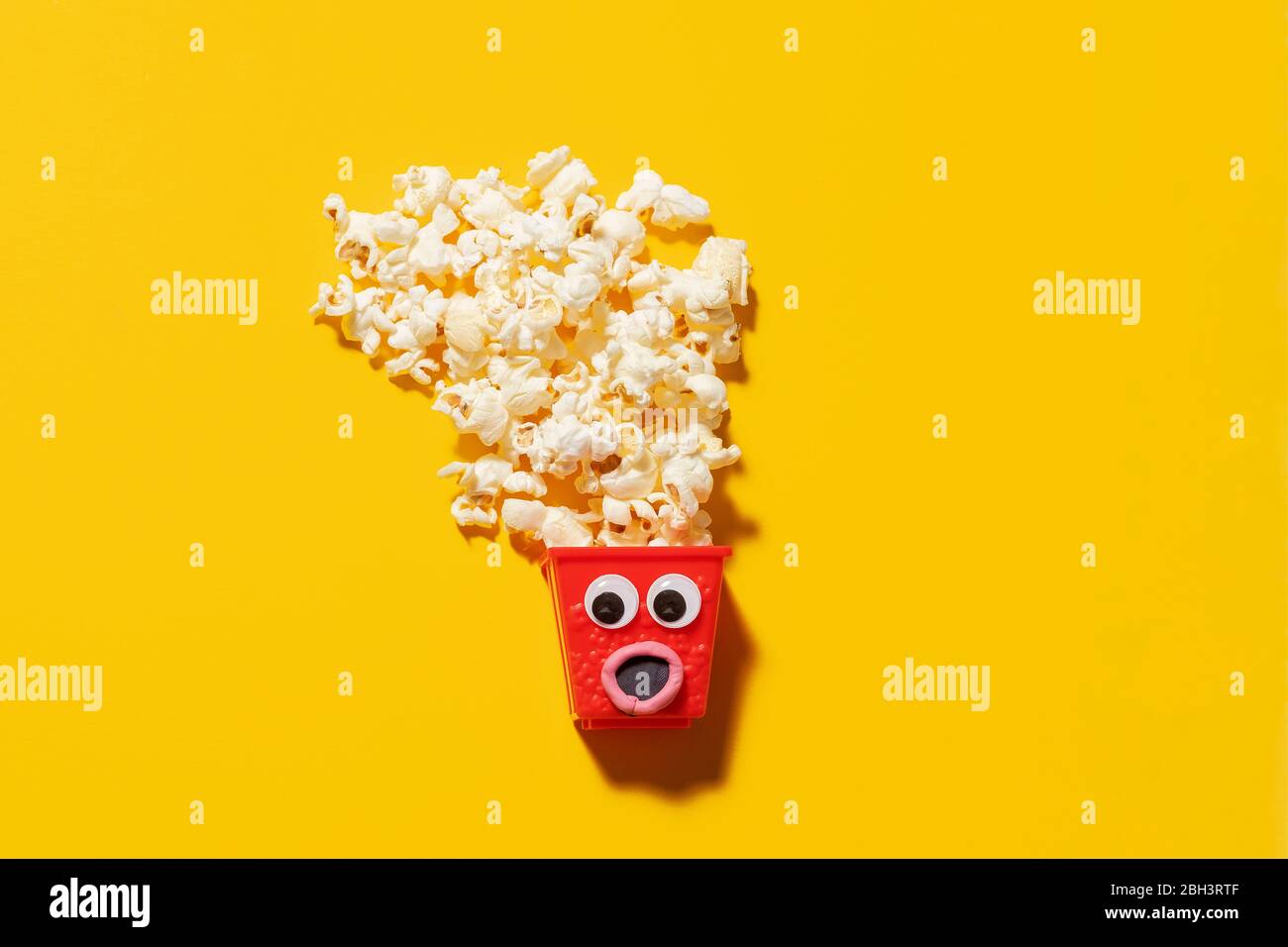 Red popcorn box carton with googly eyes and surprised face with popped ...