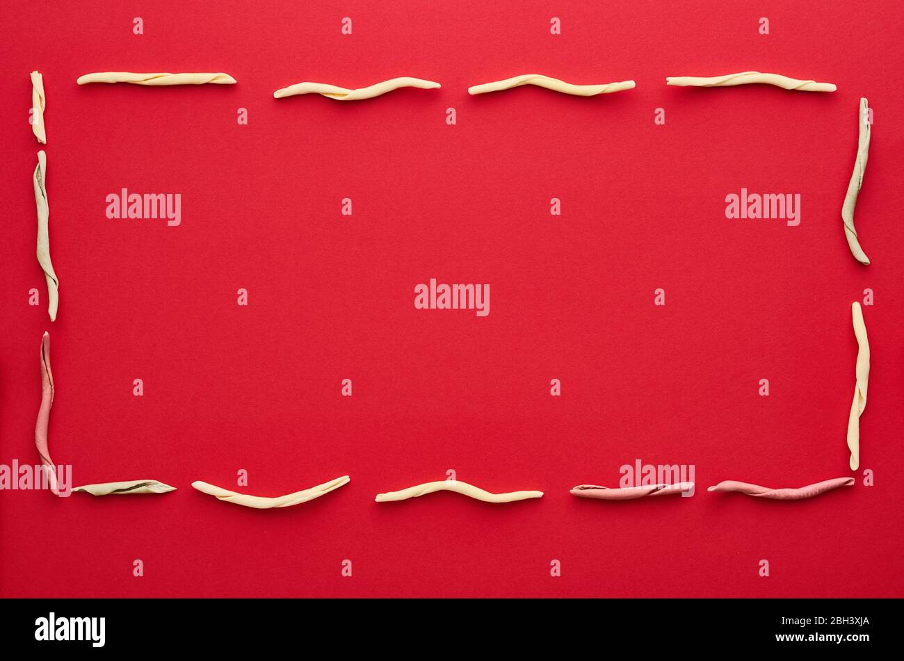Italian fileja pasta on a red background. Pasta shaped into rectangle ...