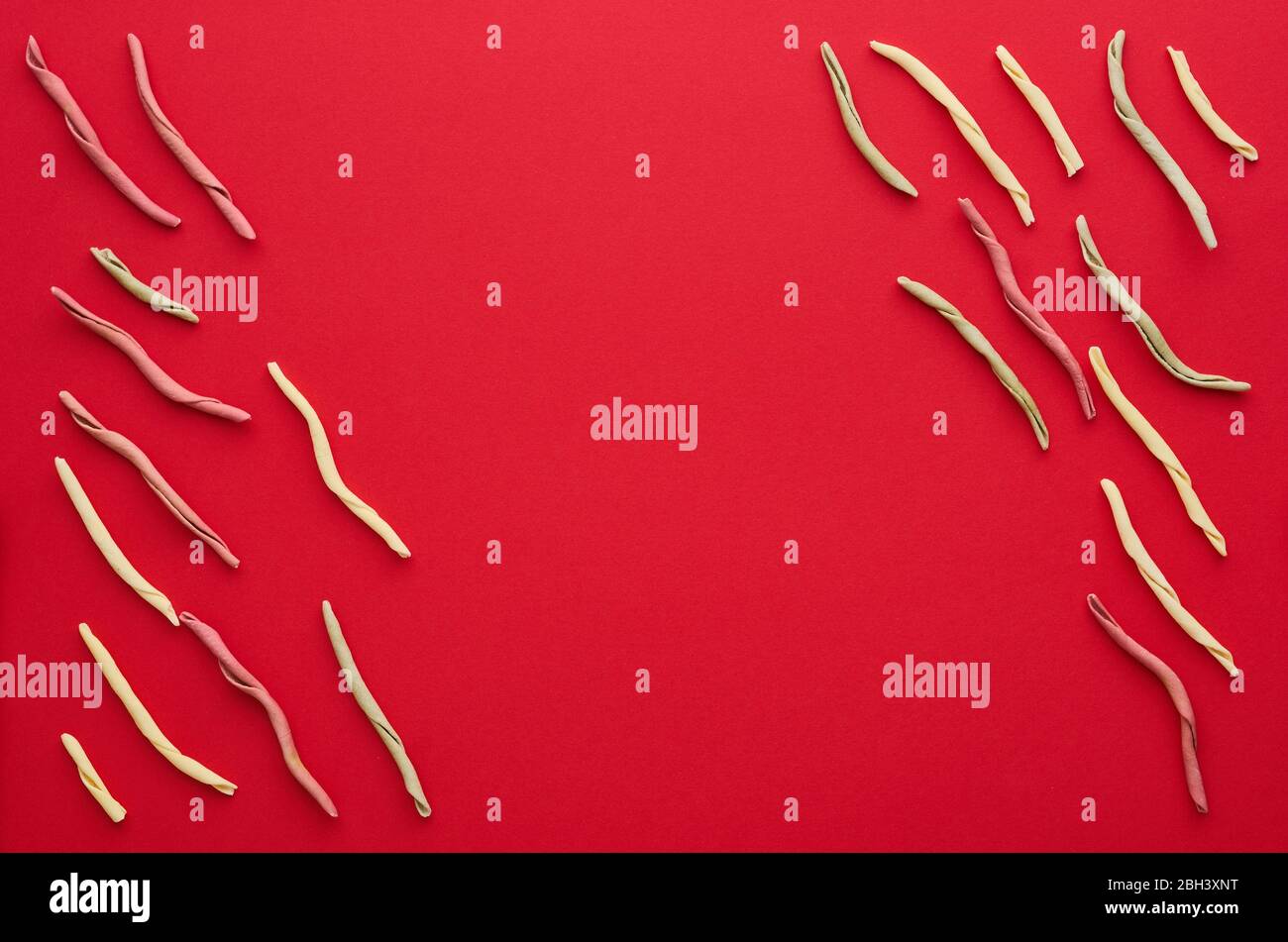 Italian fileja pasta on a red background. Flat lay photo with diagonal ...