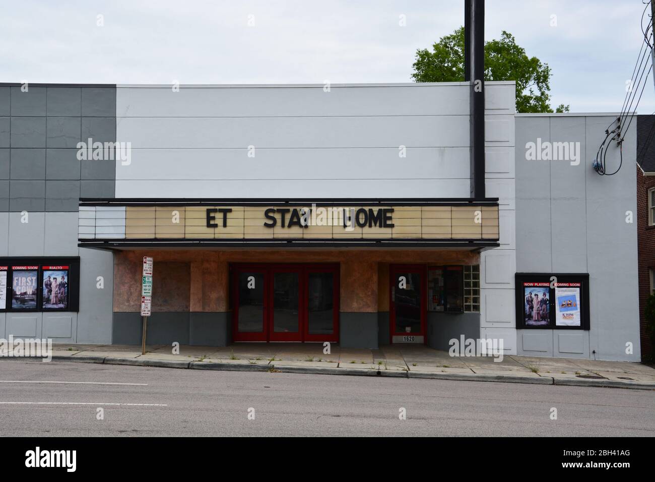 A sign reading ET Stay Home is posted on a small movie theater closed ...