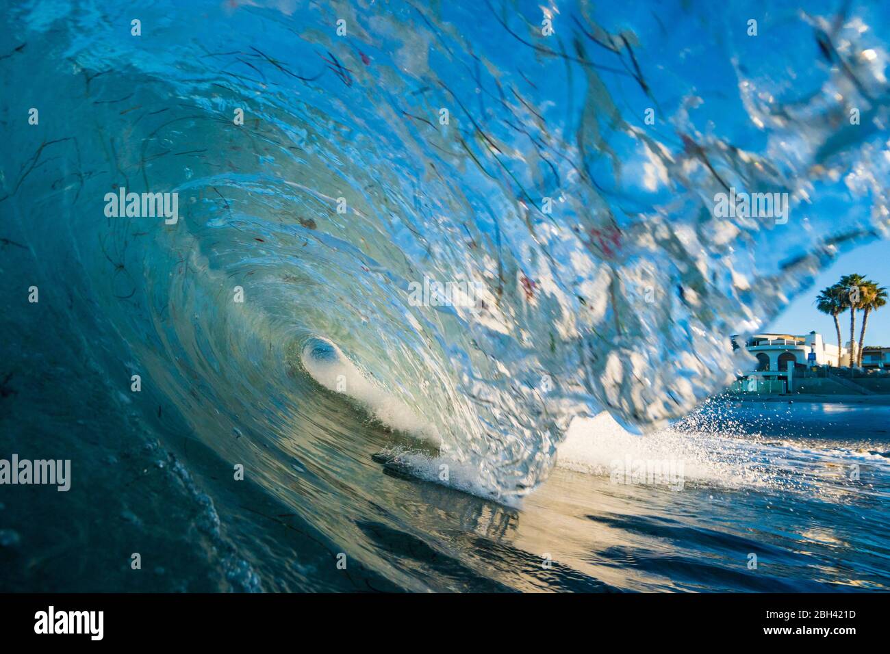 A wave breaks on a reef in a tropical paradise beach Stock Photo - Alamy