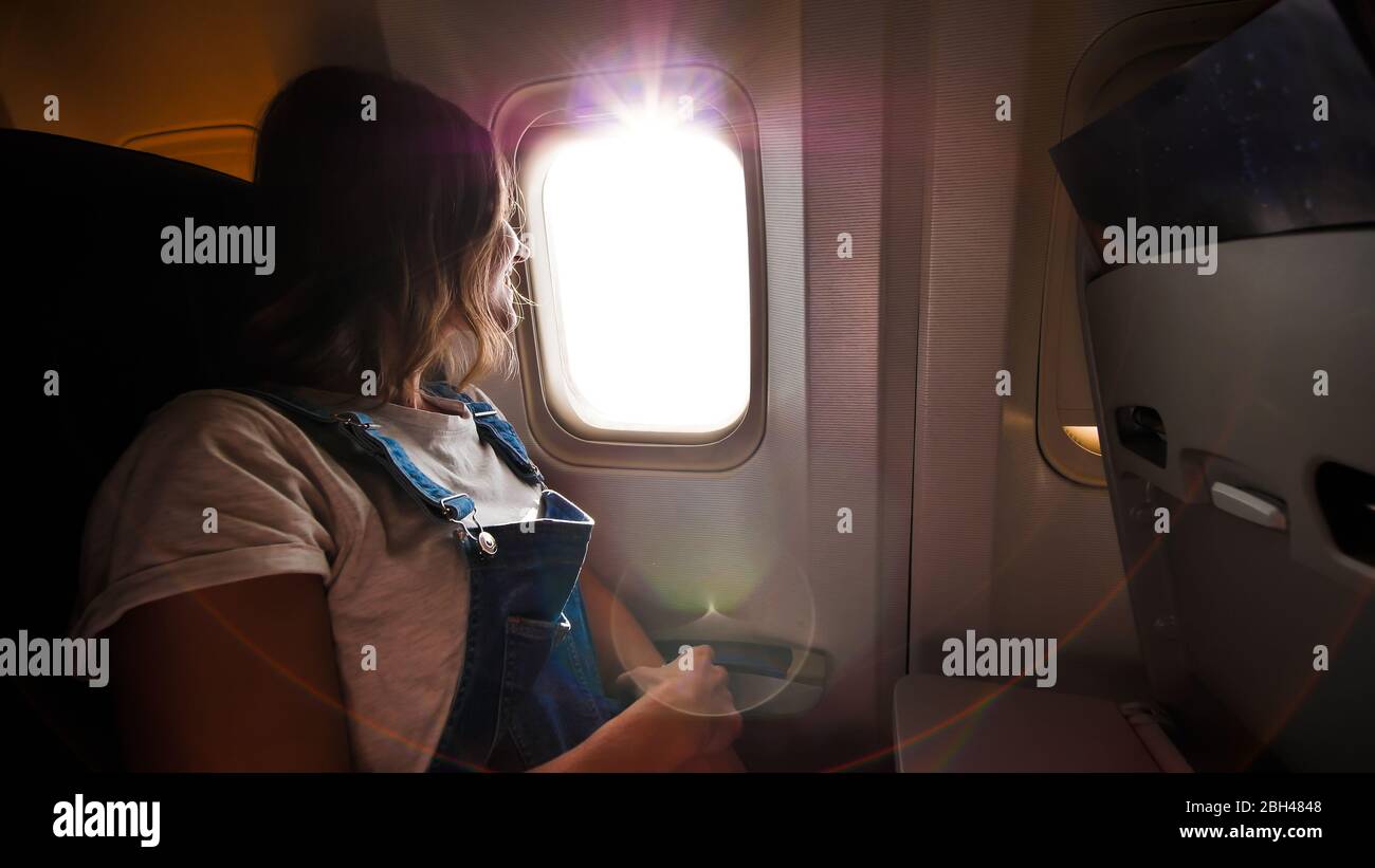 Happy girl at the window of an airplane Stock Photo - Alamy
