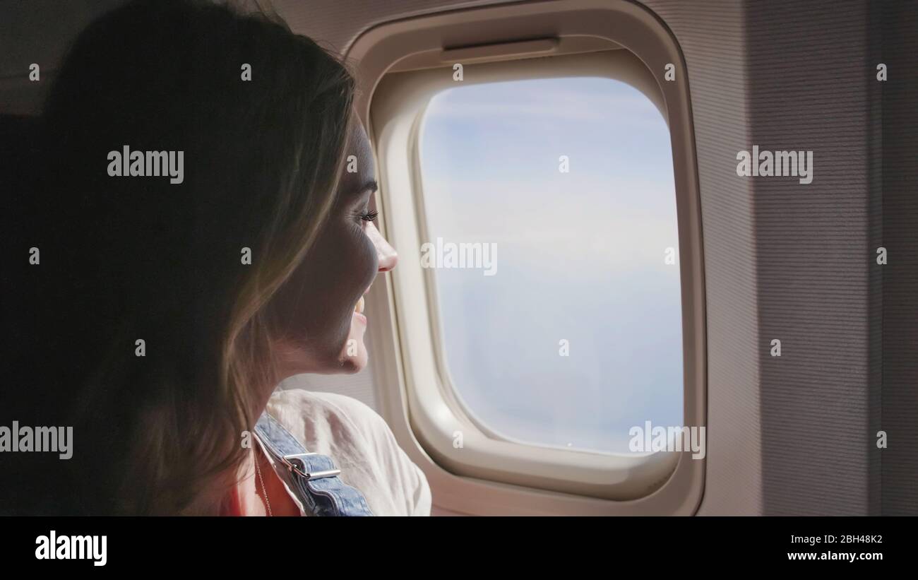 Happy girl at the window of an airplane Stock Photo - Alamy