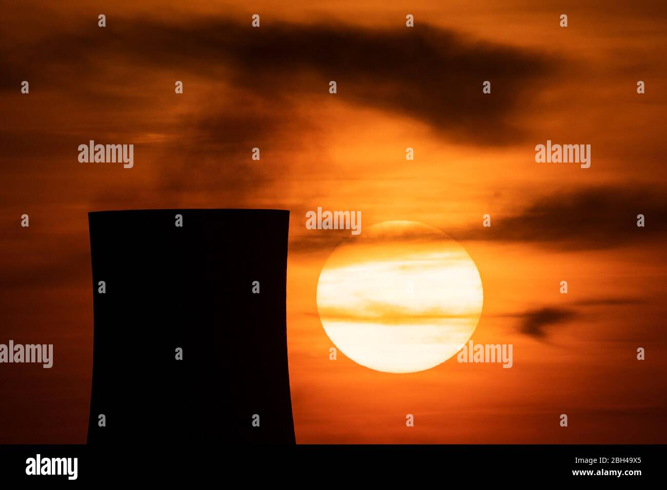 Stommeln, Germany. 23rd Apr, 2020. The sun sets behind a cooling tower ...
