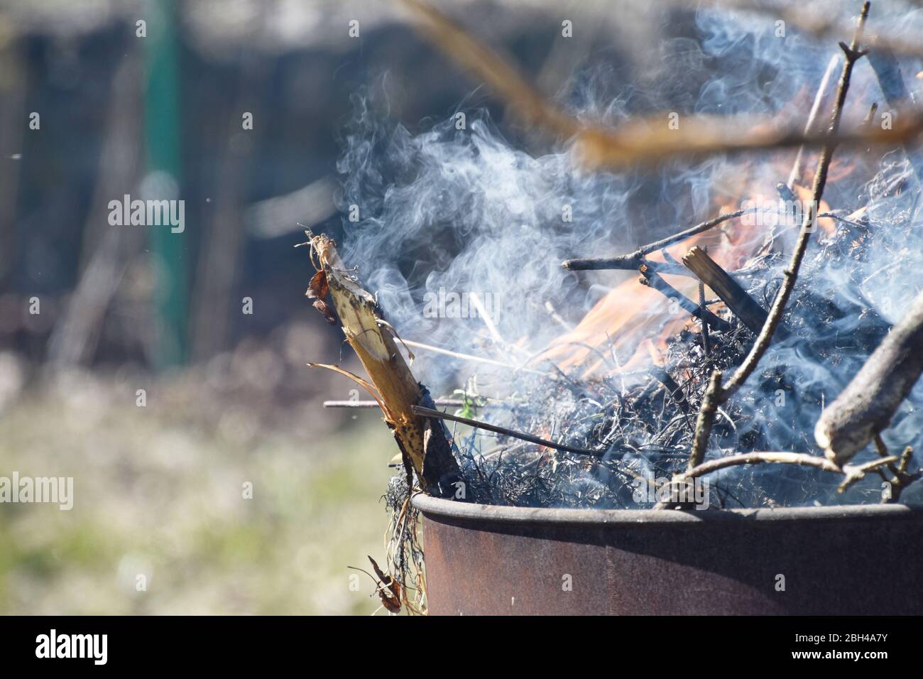 Wood burning in a rusty barrel Stock Photo - Alamy