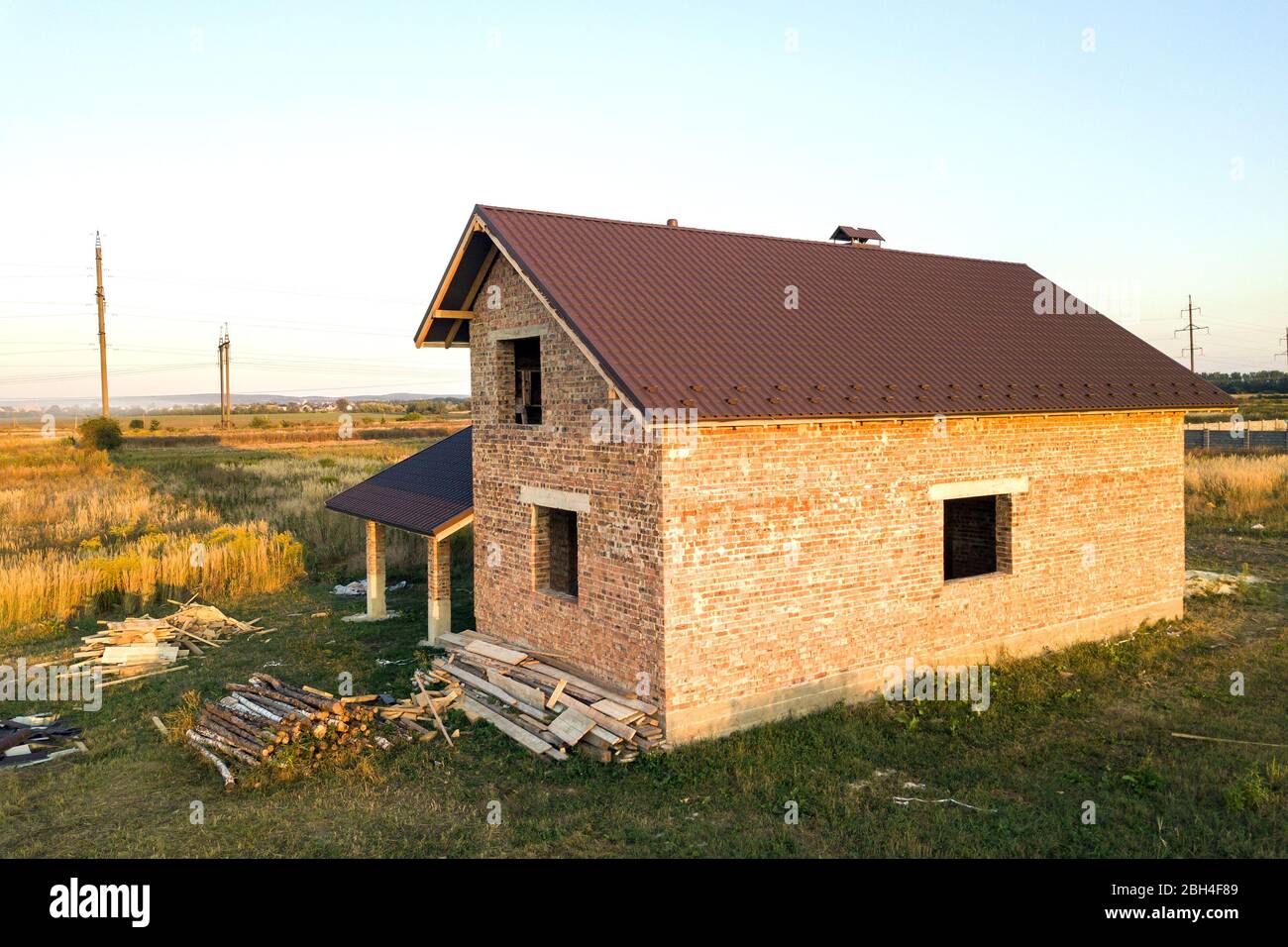 Unfinished brick house with wooden roof structure covered with metal ...