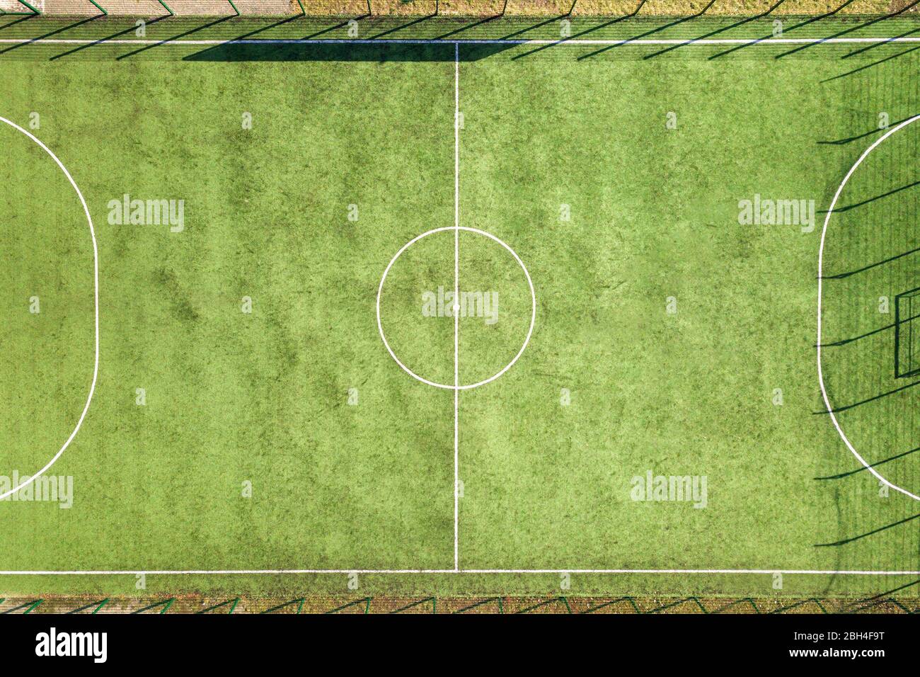 Top down aerial view of green football sports field and players playing ...