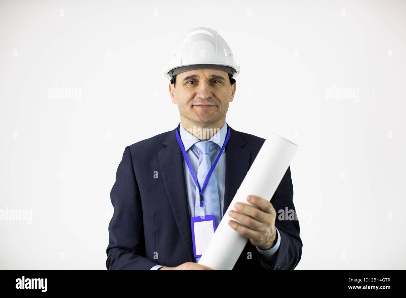 positive engineer constructor in helmet formal clothing holds rolled-up ...