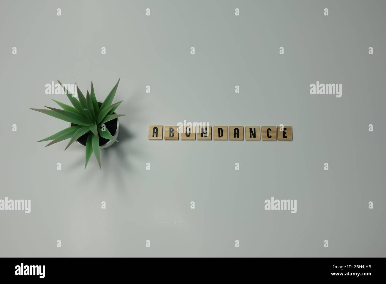 The word Abundance written in wooden letter tiles on a white background ...