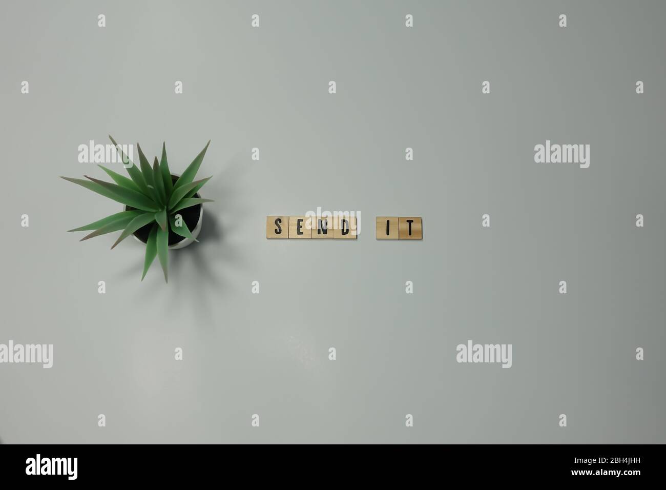 The word Send it written in wooden letter tiles on a white background ...