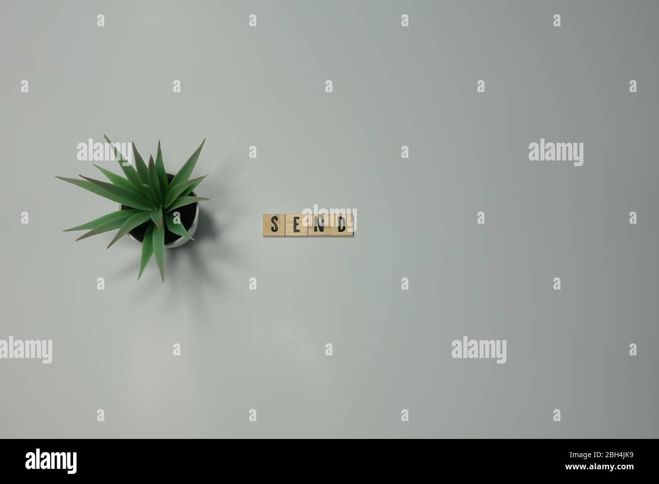 The word Send written in wooden letter tiles on a white background ...