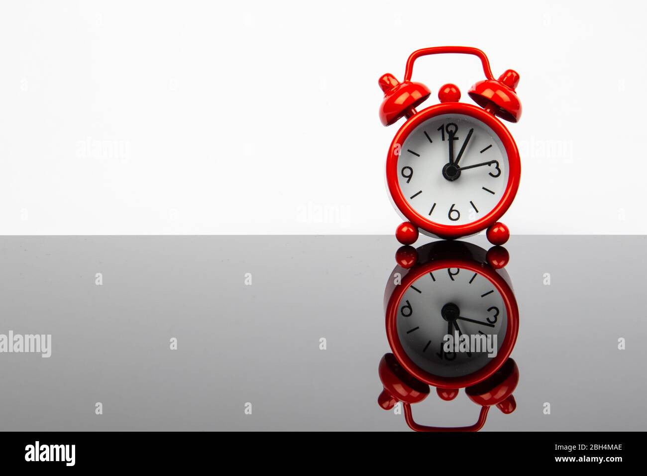 Red retro alarm clock with reflection on a white background Stock Photo ...