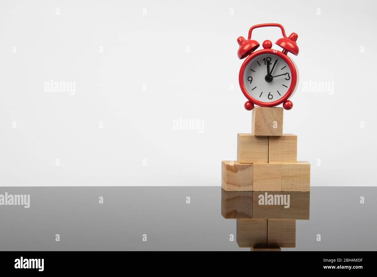 Red alarm clock and wooden cube block with leadership concept Stock ...