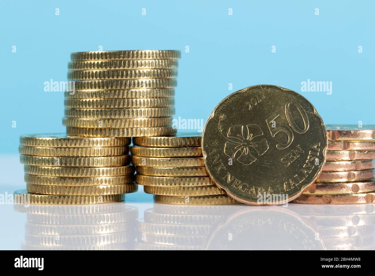 Close-up Malaysian ringgit coins with blue background and reflection ...