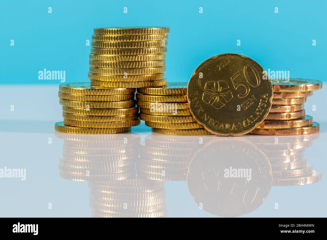 Close-up Malaysian ringgit coins with blue background and reflection ...