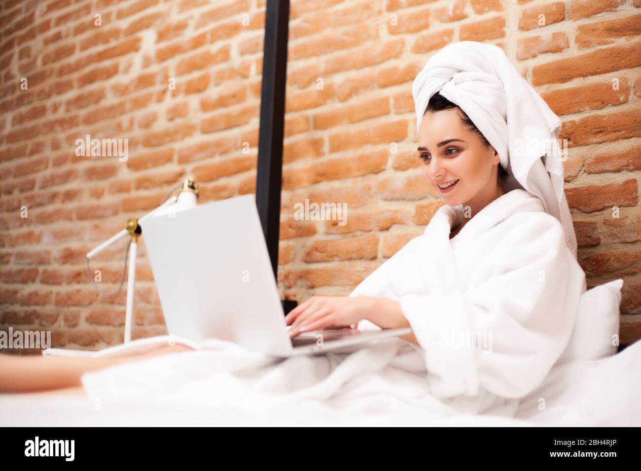 Pretty woman after shower chatting on a laptop Stock Photo - Alamy