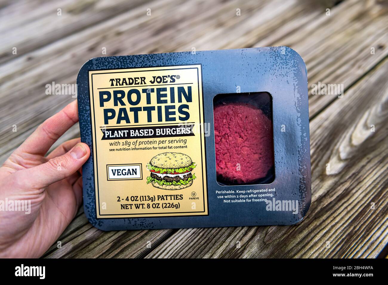 Reston, USA - January 25, 2020: Hand holding Trader Joe's private label protein patties sign of ...