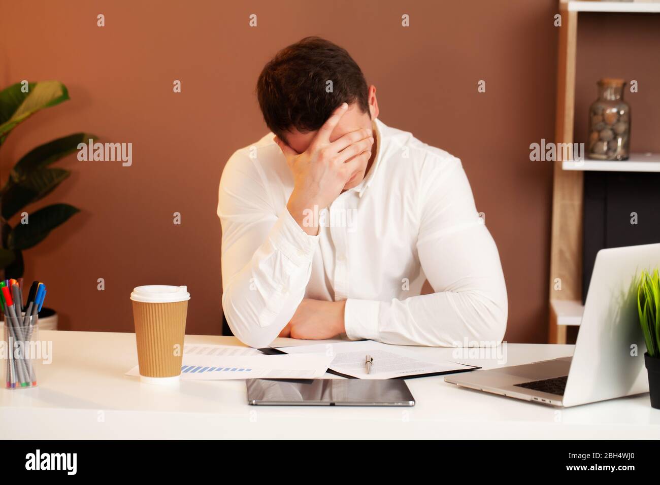 Tired man working at company office at computer Stock Photo - Alamy