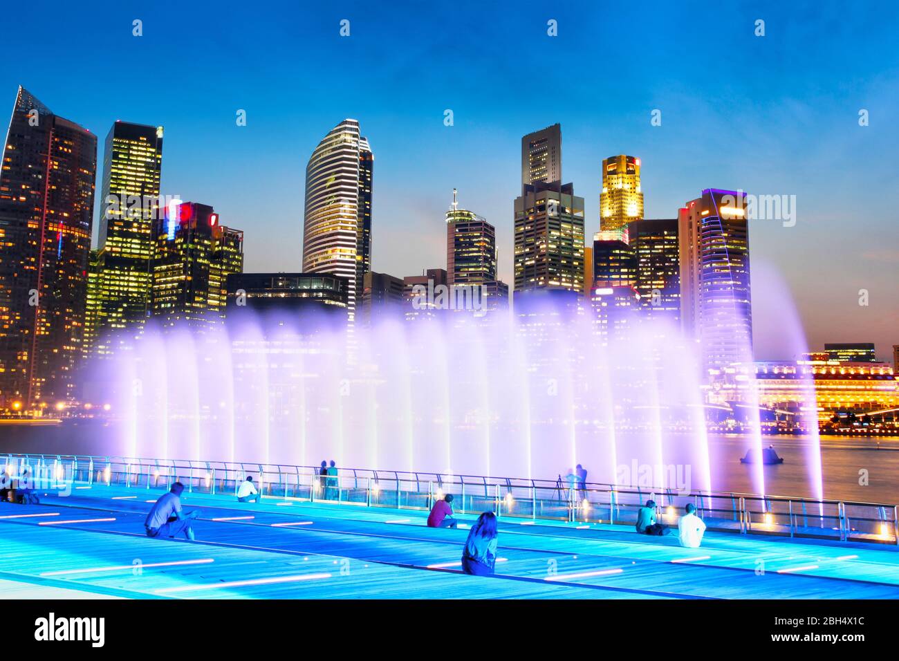 Small crowd of unidentifiable spectators watching a sea fountain at the ...