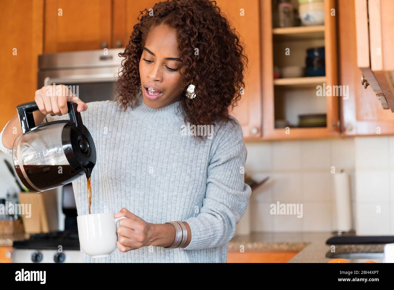 Tired woman pouring coffee Stock Photo - Alamy