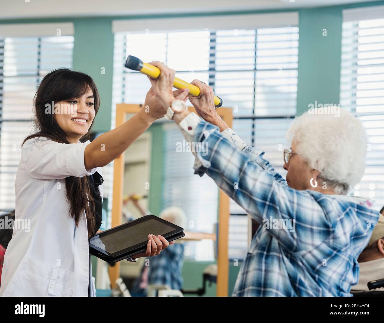 Smiling doctor helping senior woman hold pole Stock Photo - Alamy