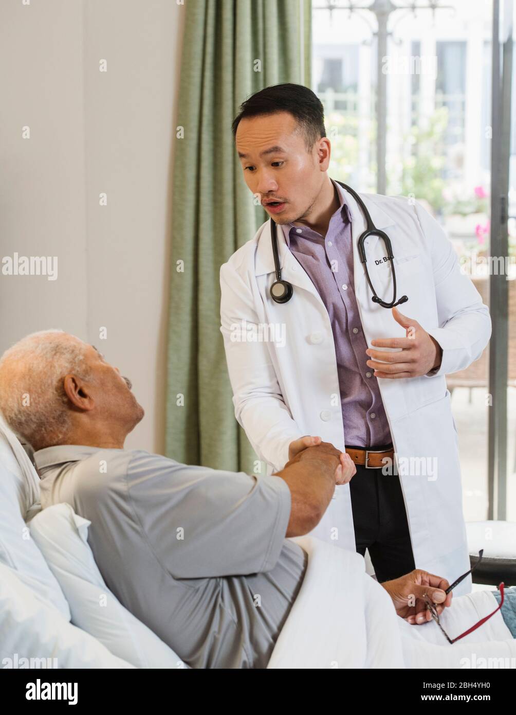 Senior man and doctor shaking hands Stock Photo - Alamy