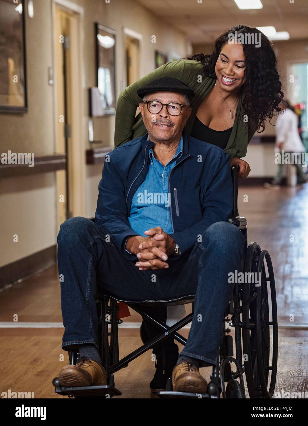 Smiling woman pushing senior man in wheelchair Stock Photo - Alamy