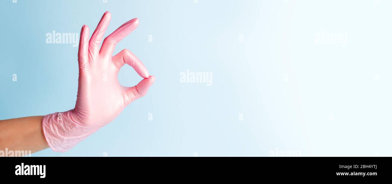 Female hand in cosmetology medicine pink glove pointing up okay, yes ...