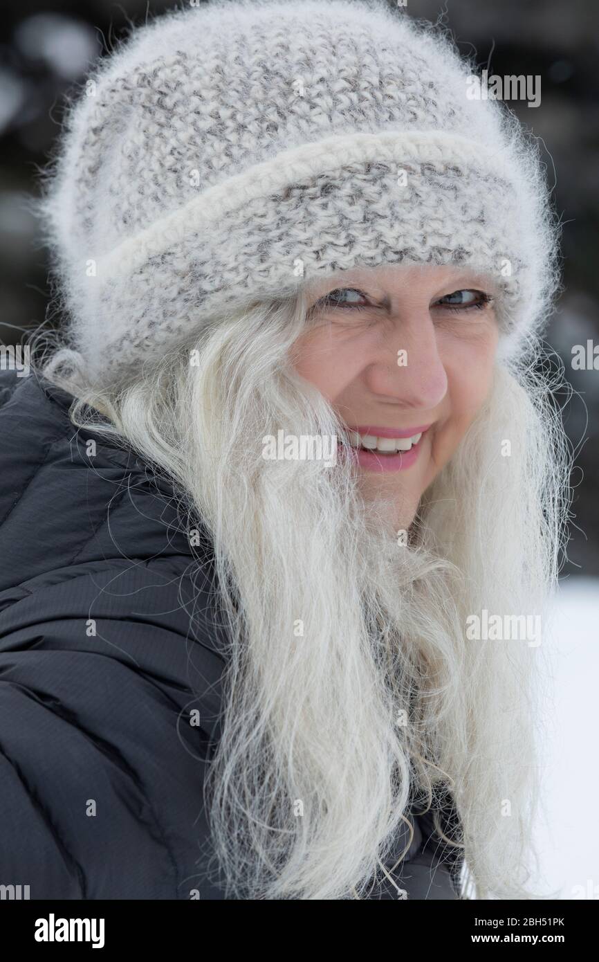 Smiling woman wearing hat in snow Stock Photo - Alamy
