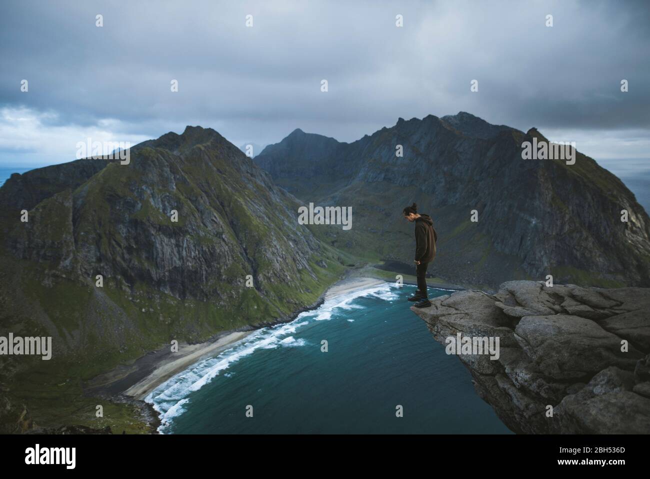 Man standing on cliff at Ryten mountain in Lofoten Islands, Norway ...