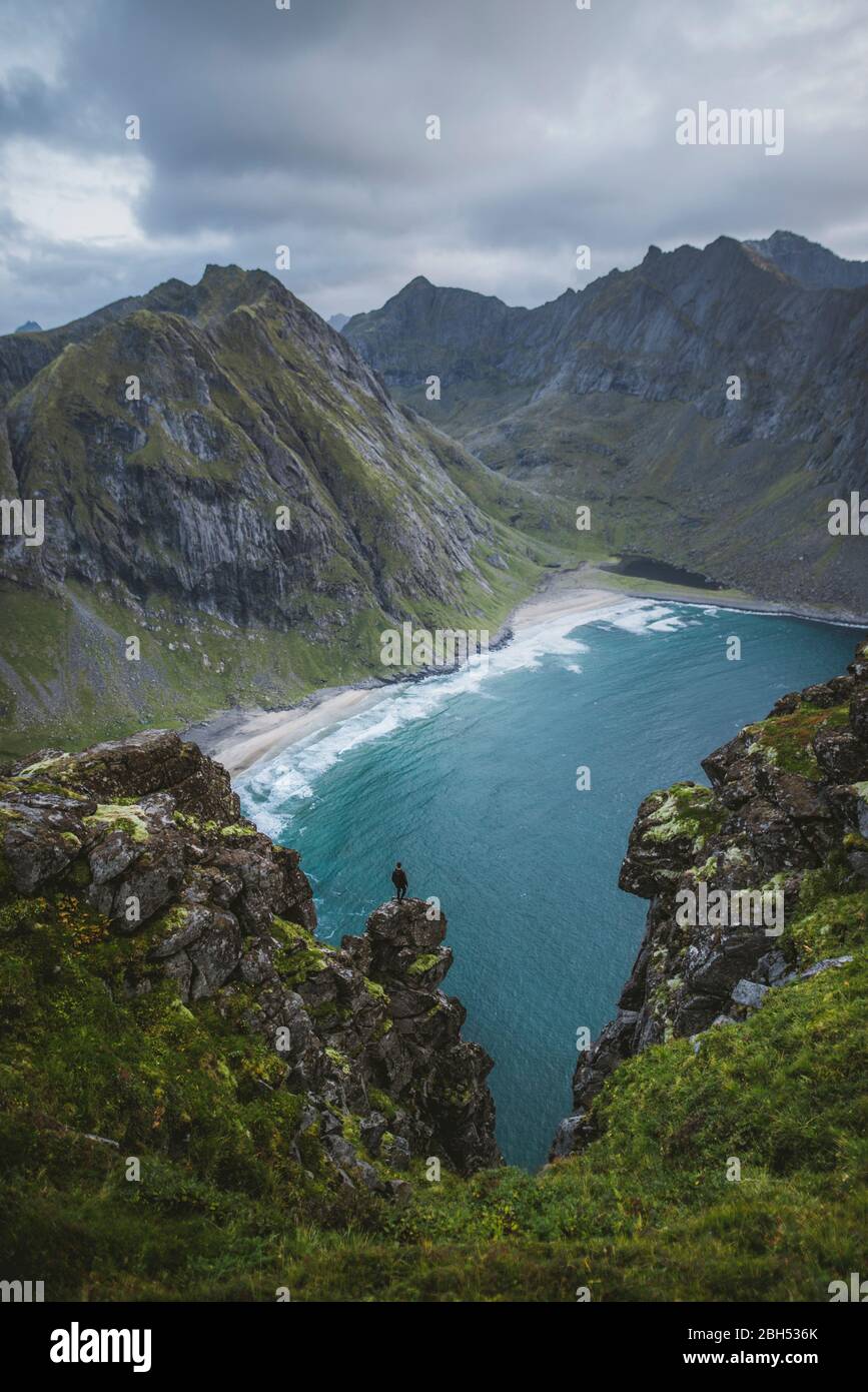 Man standing on cliff at Ryten mountain in Lofoten Islands, Norway ...
