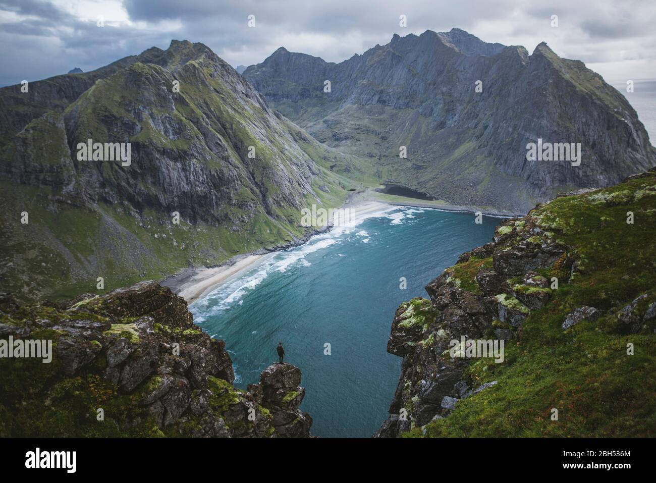 Man standing on cliff at Ryten mountain in Lofoten Islands, Norway ...