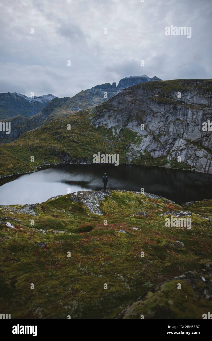 Man standing on rock by lake in Lofoten Islands, Norway Stock Photo - Alamy