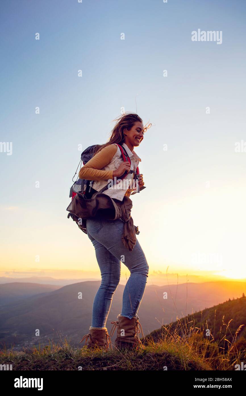 Portrait of happy young woman hiking in the mountains Stock Photo - Alamy