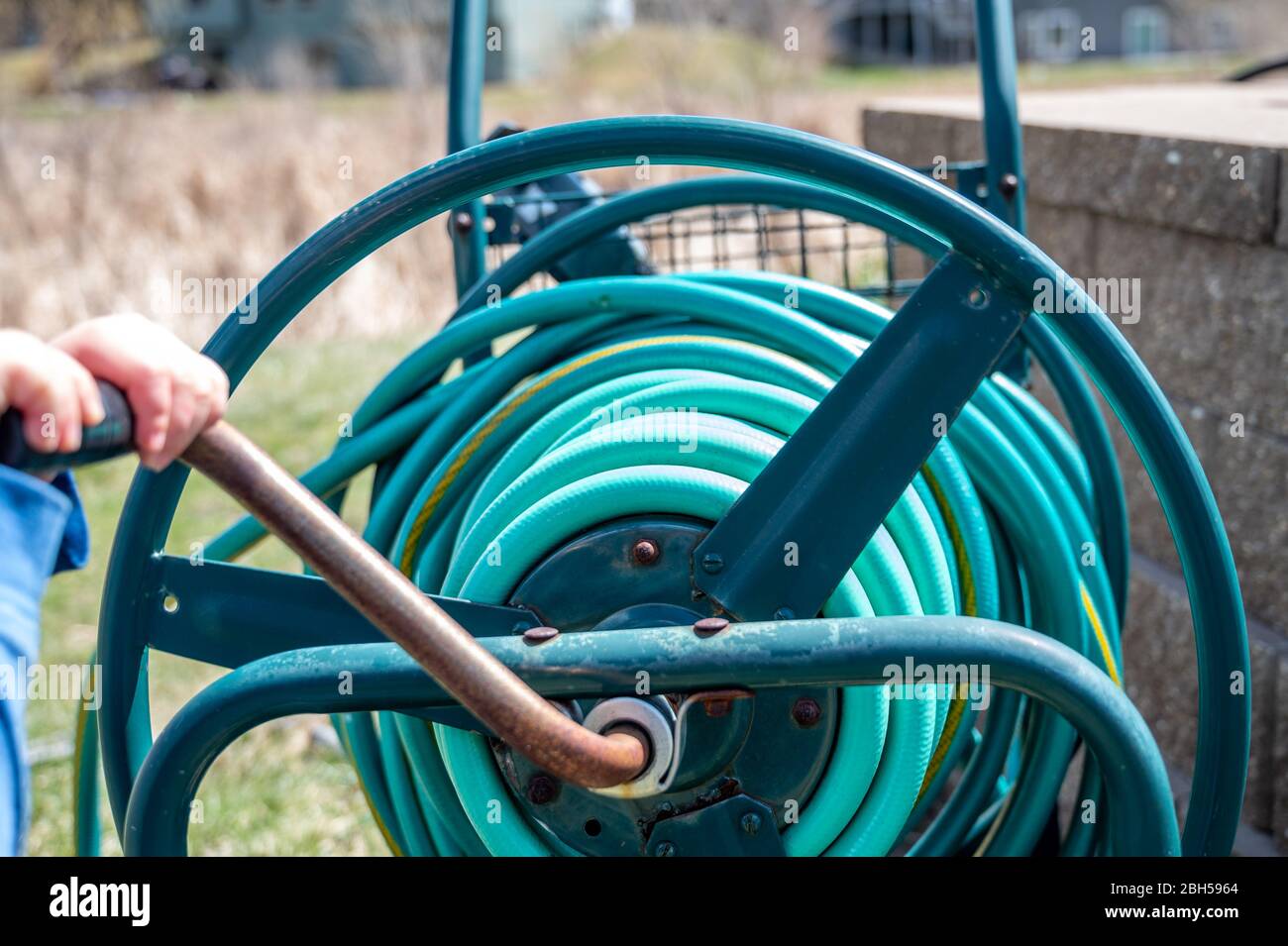Selective focus on front bar on a wound garden hose storage cart with ...