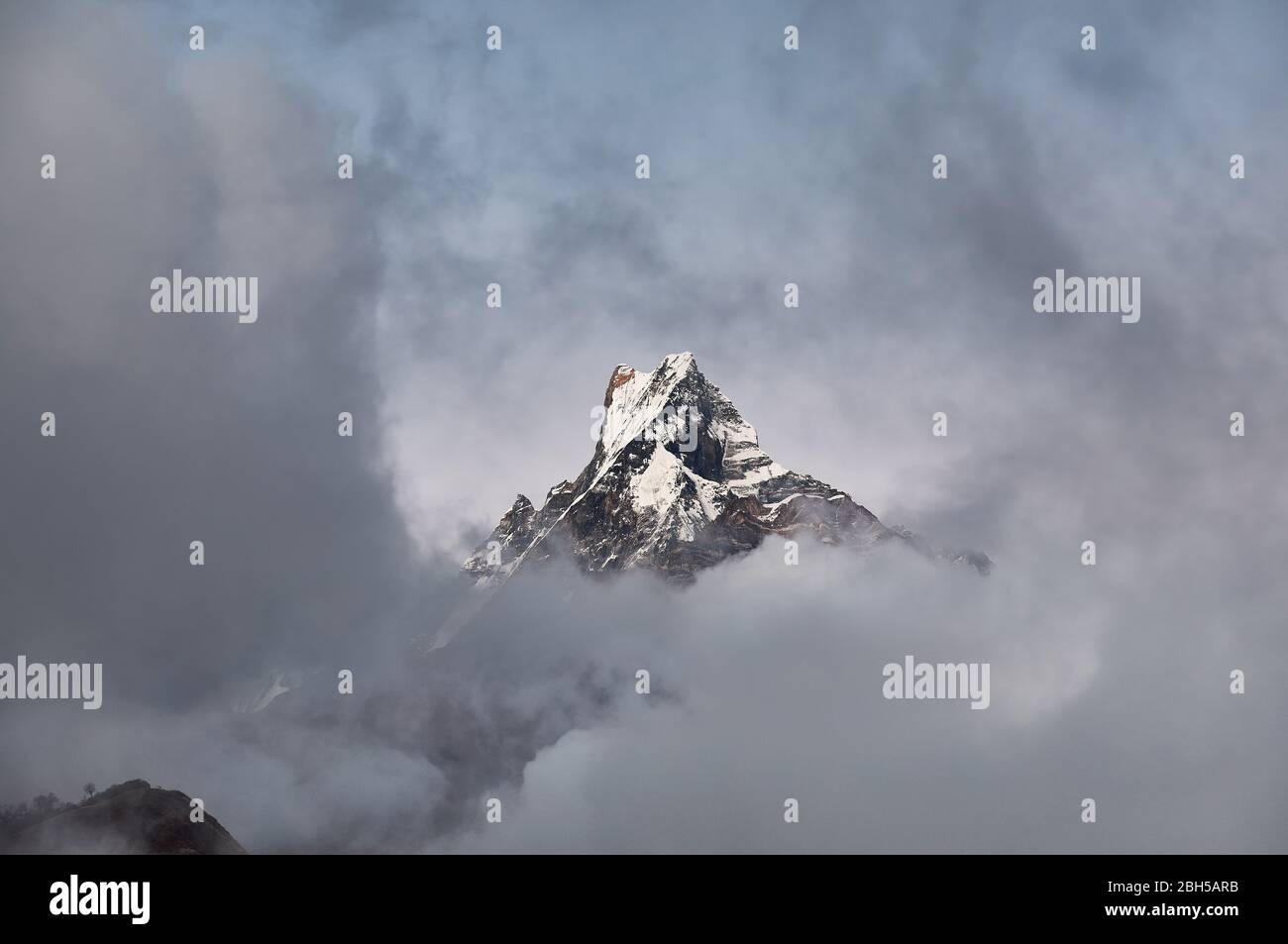 Machapuchare Fish Tale peak surrounded by clouds in the Himalayas ...