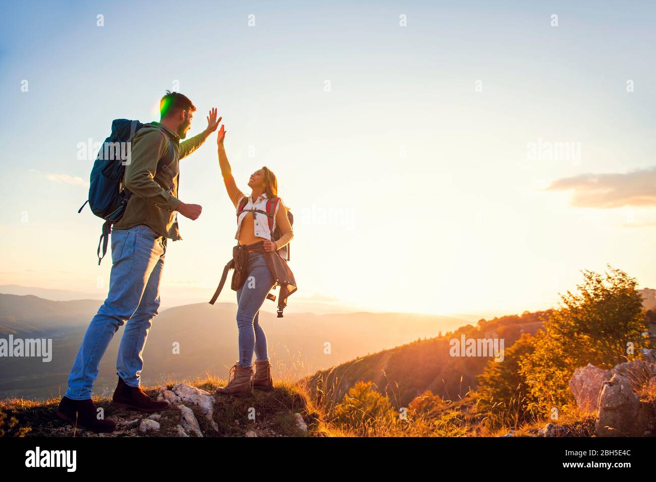 Couple on Top of a Mountain Shaking Raised Hands Stock Photo - Alamy