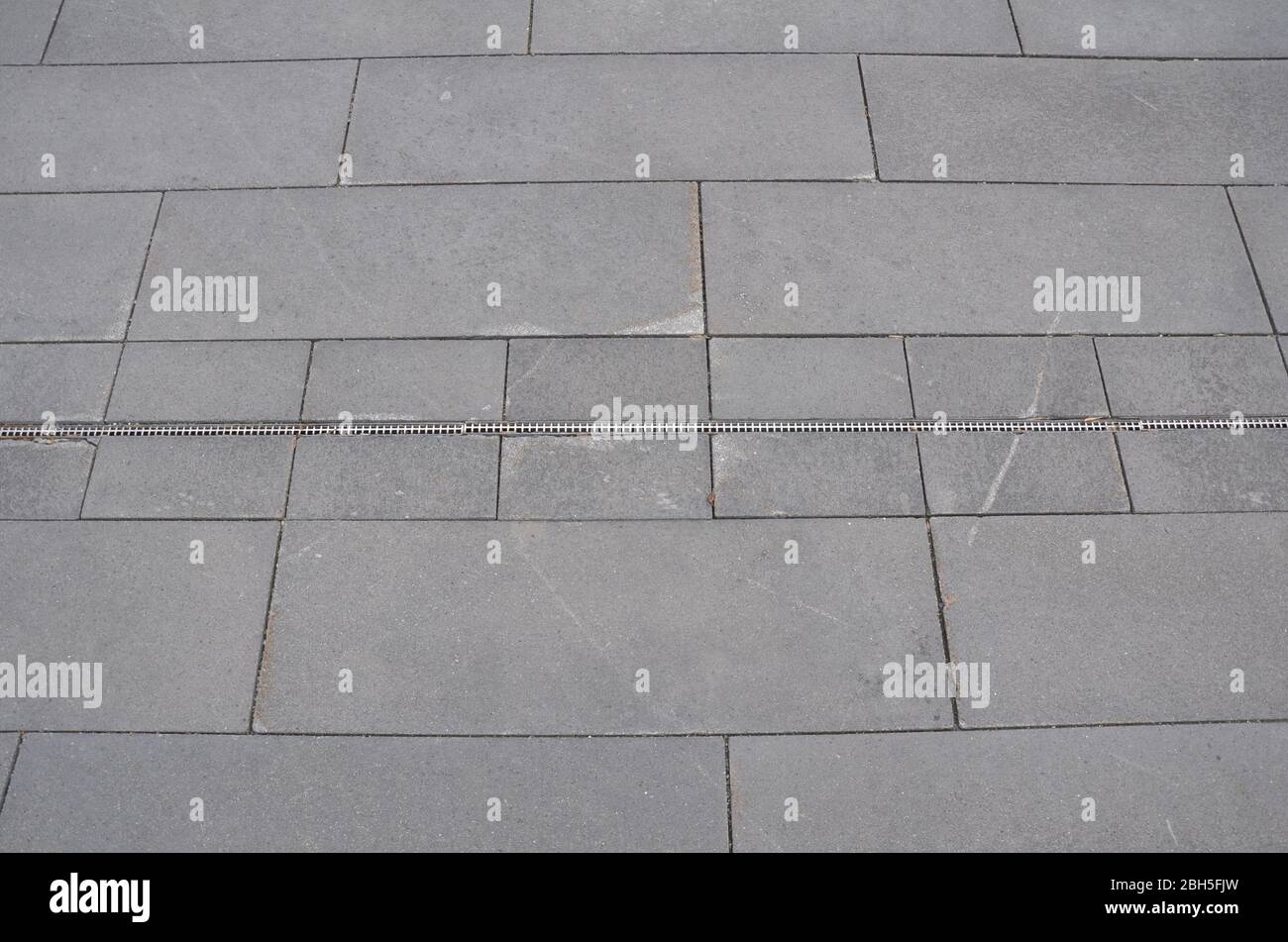 grey stone rectangle tiles with drain on ground Stock Photo - Alamy