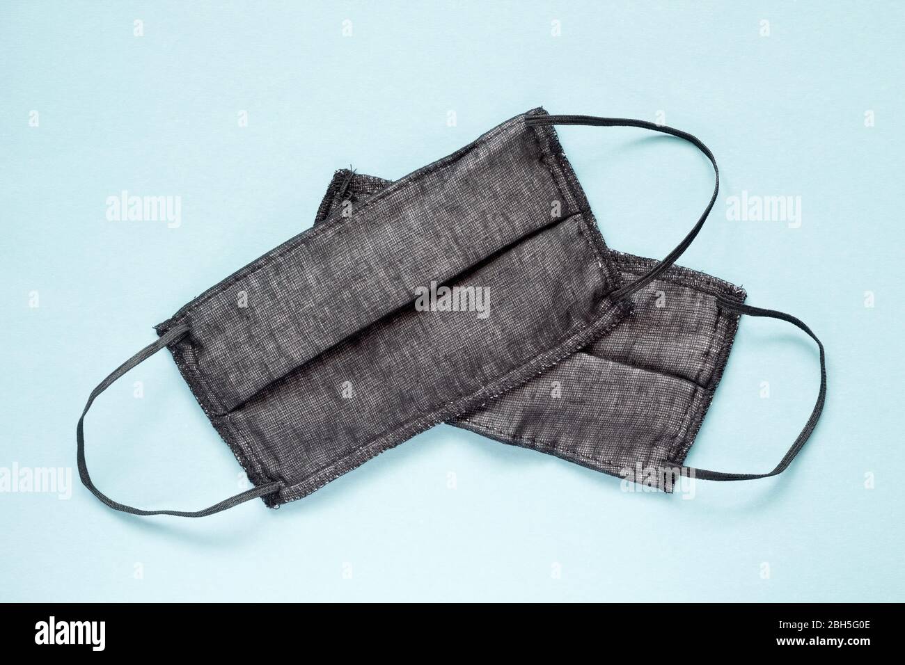 Medical fabric mask on blue background. Black handmade cotton gauze ...