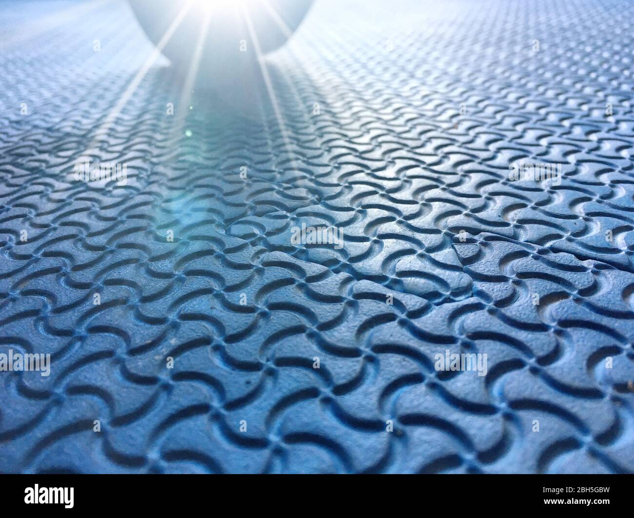 The photo of The blue rubber gym floor with the shadow of dumbell ...