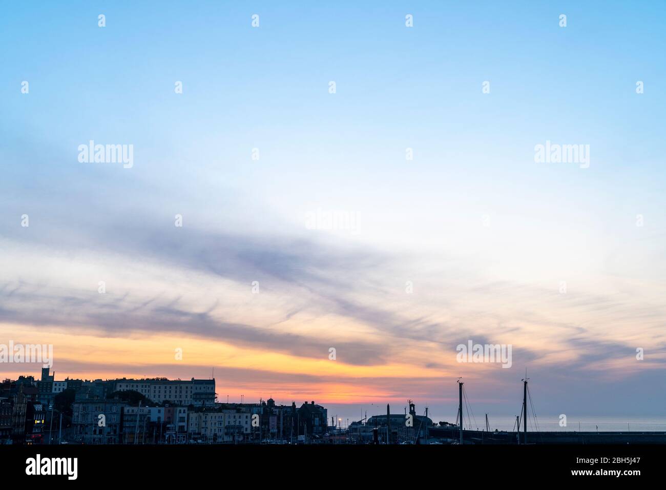 Dawn sky at first light over the skyline of the seafront town of ...